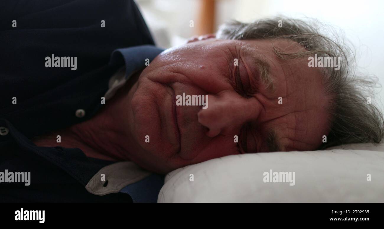 Old man lays down in bed to nap. Senior guy resting napping Stock Photo ...