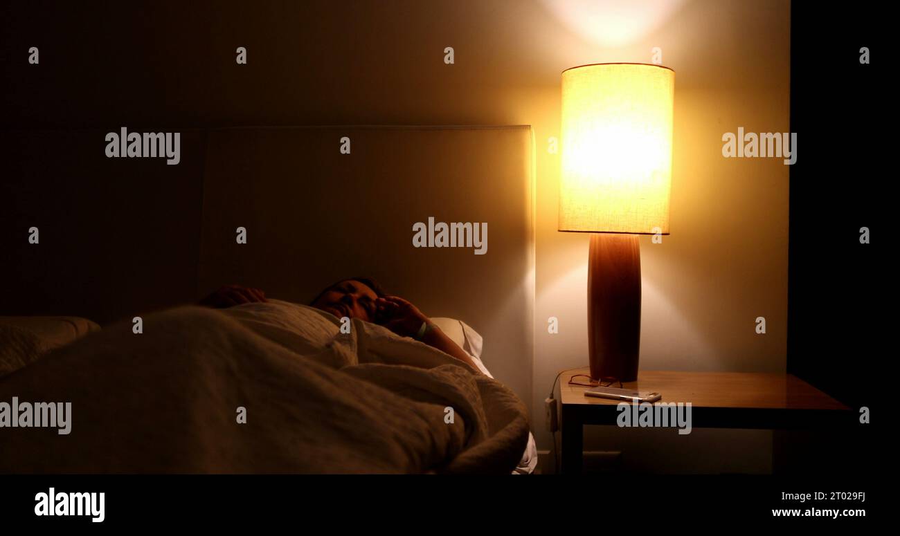 Person turns night stand light ON and gets out of bed Stock Photo - Alamy