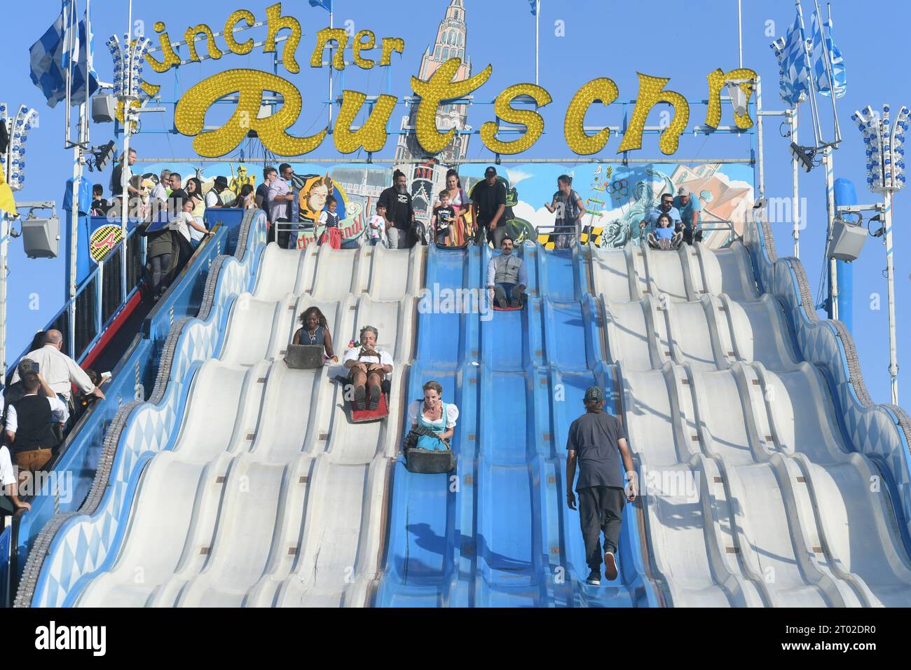 Munich, Germany. 03rd Oct, 2023. Oktoberfest visitors slide on the ...
