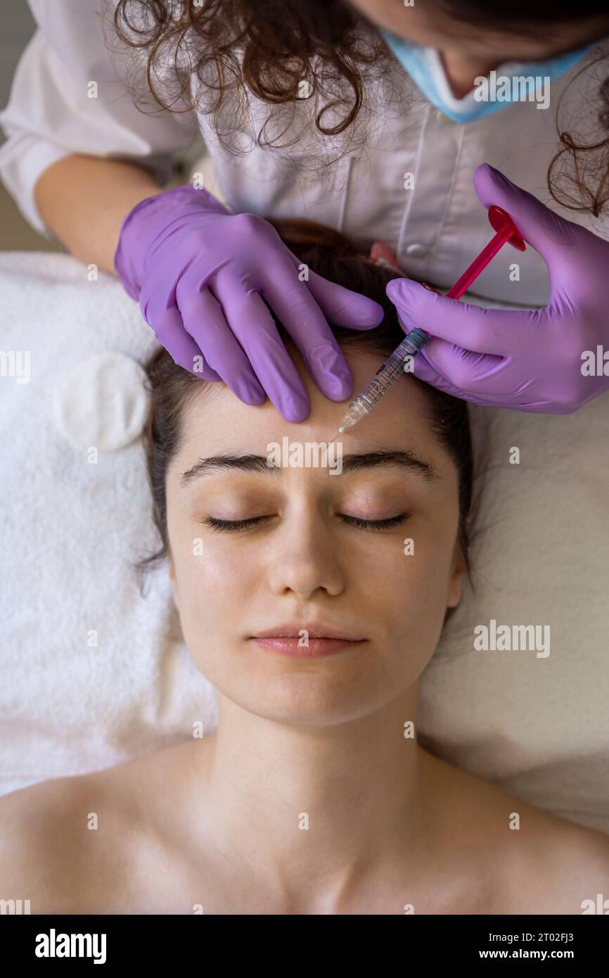 Cosmetologist Making Rejuvenating Anti Wrinkle Injections On The Face