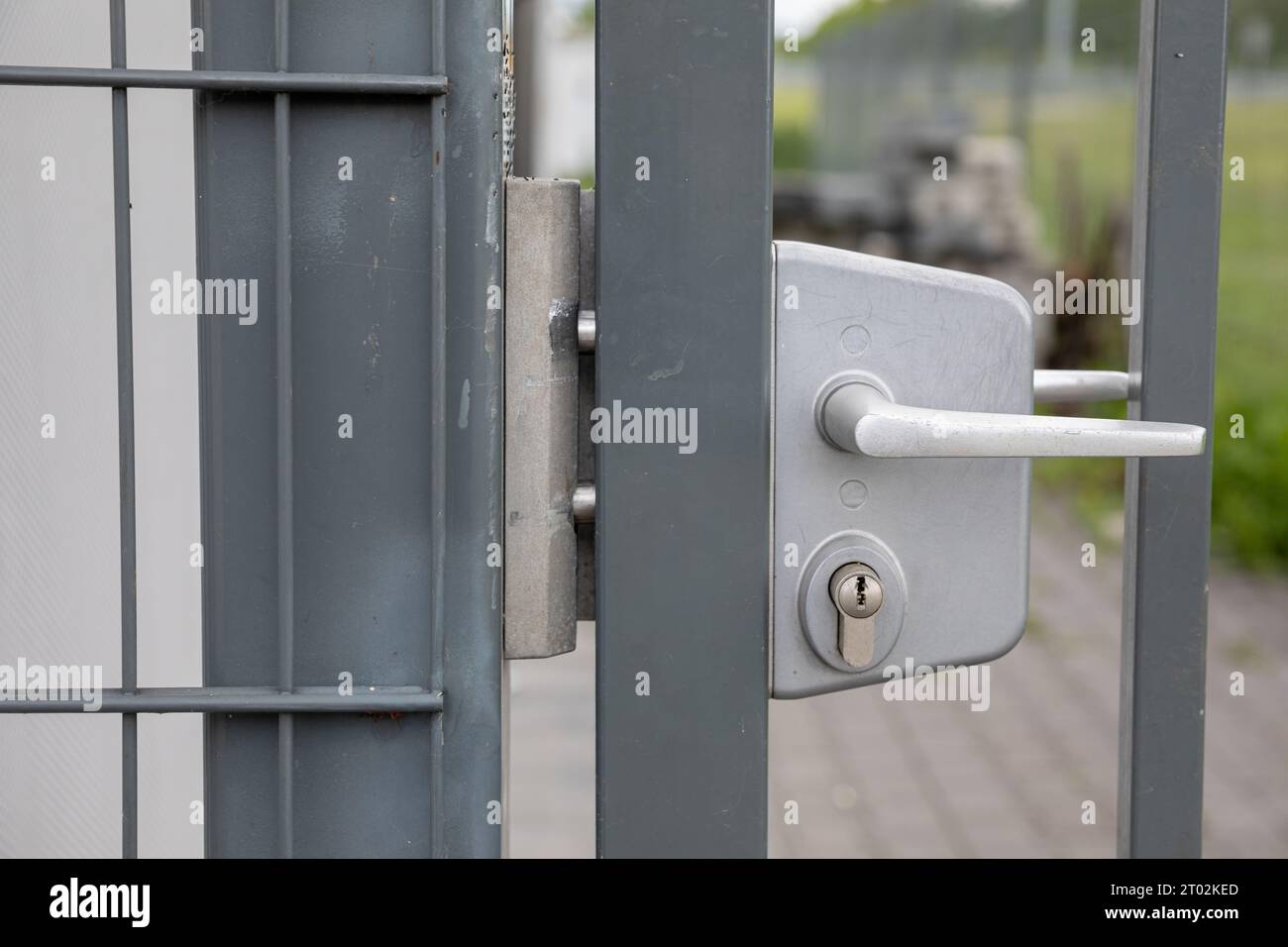 A close-up front view of the white handle on the steel fence gate Stock ...