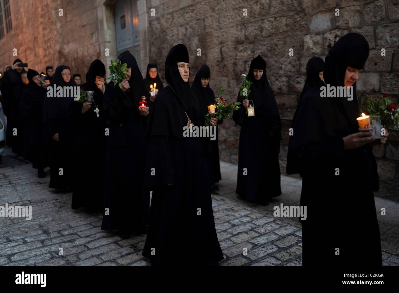 FILE - Christian orthodox nuns hold candles and flowers as they walk in ...