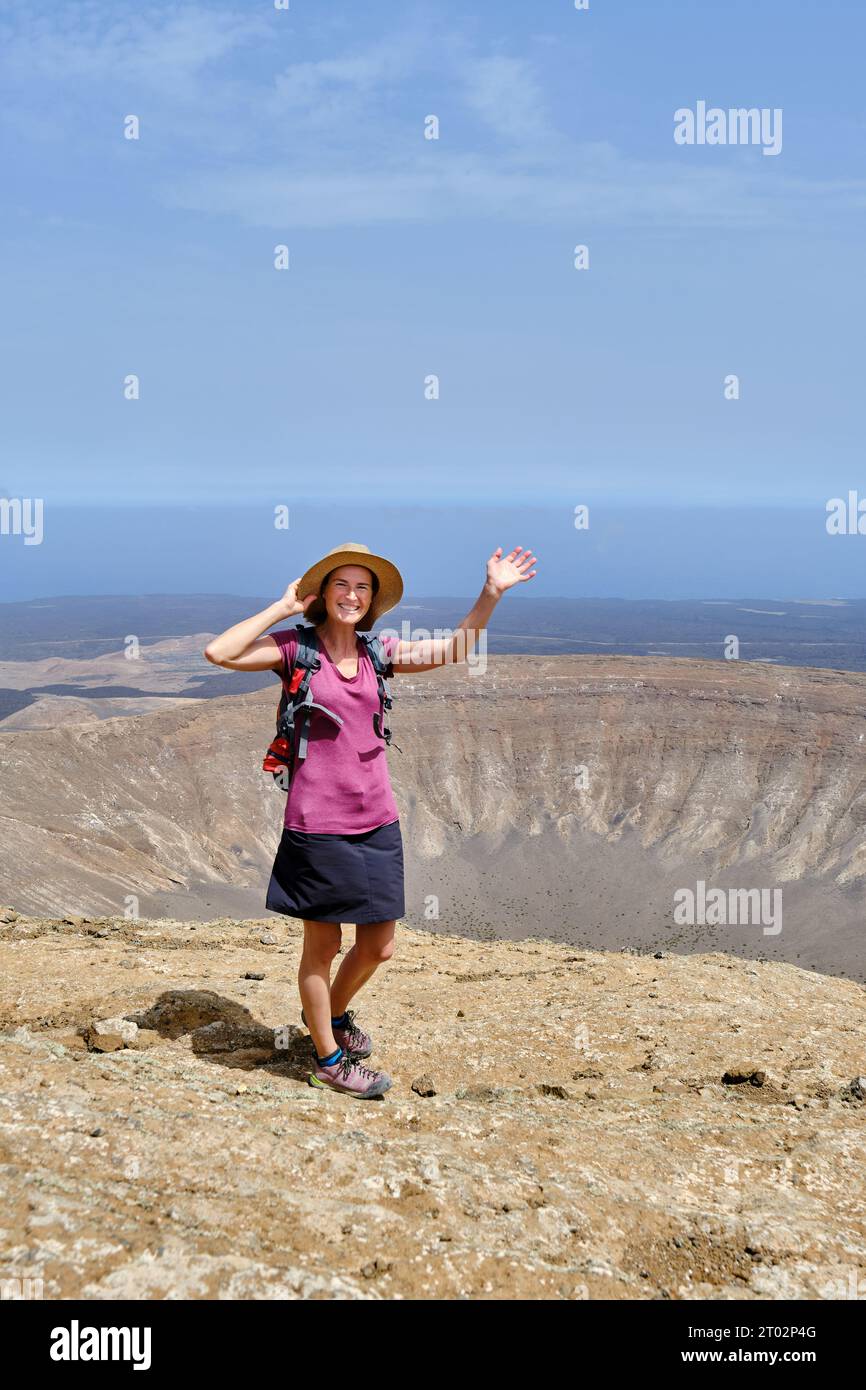 Happy woman climbing to the top of a volcano crater Stock Photo - Alamy