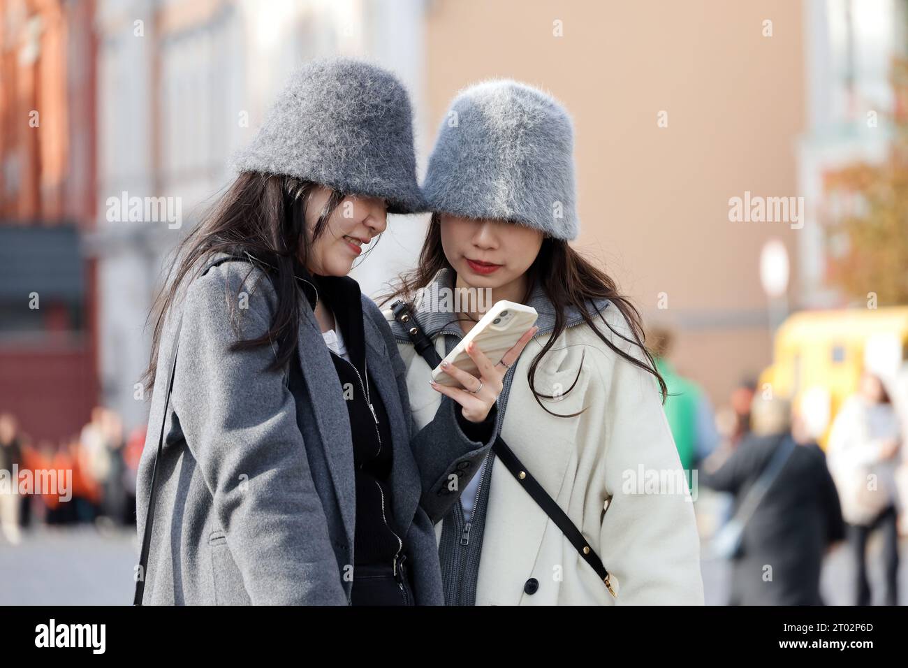 Two asian girls in hats standing on Red square in Moscow. Tourists with ...