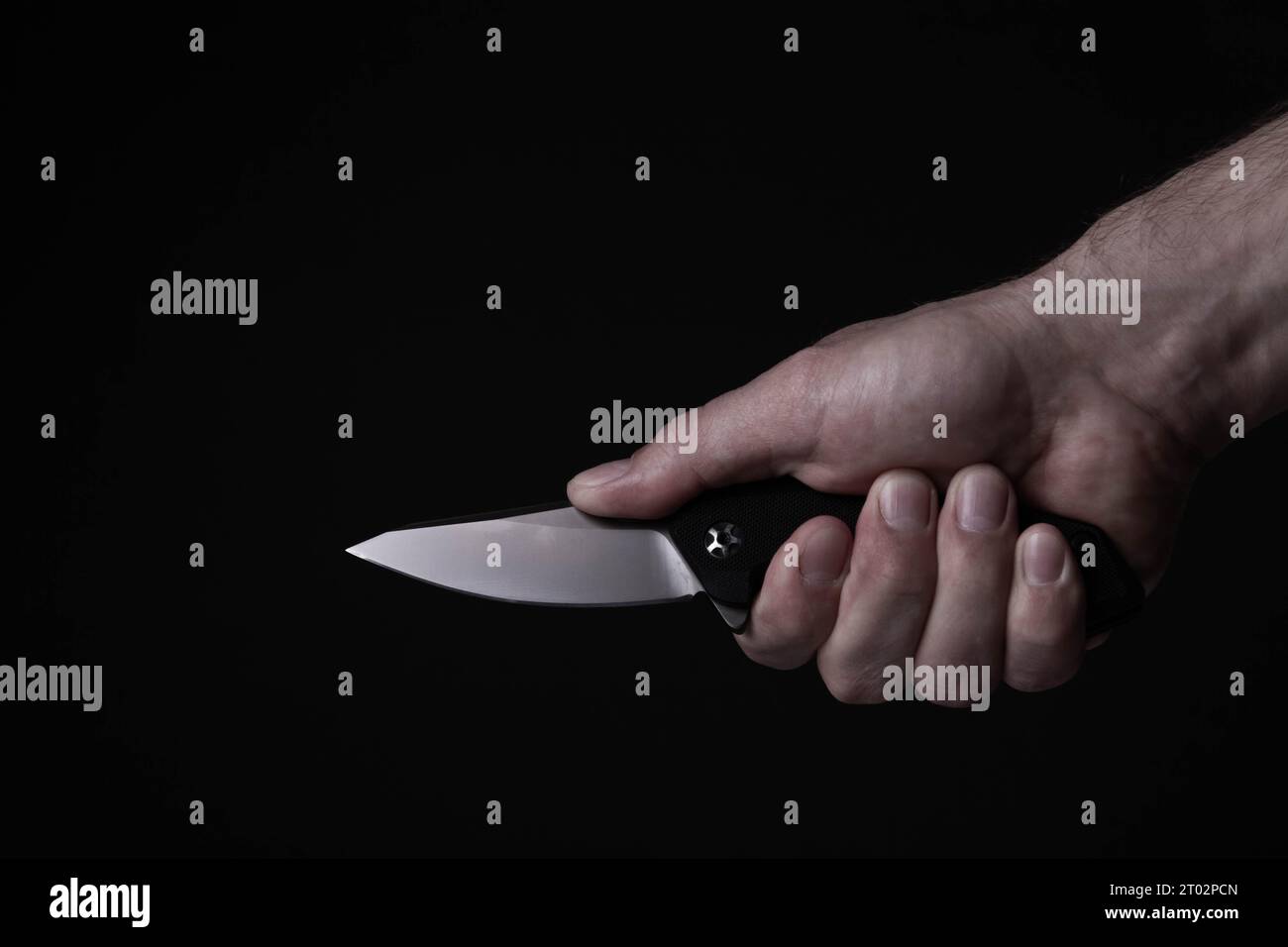 A sharp knife in the man's hand. The use of cold weapons. Knife attack ...