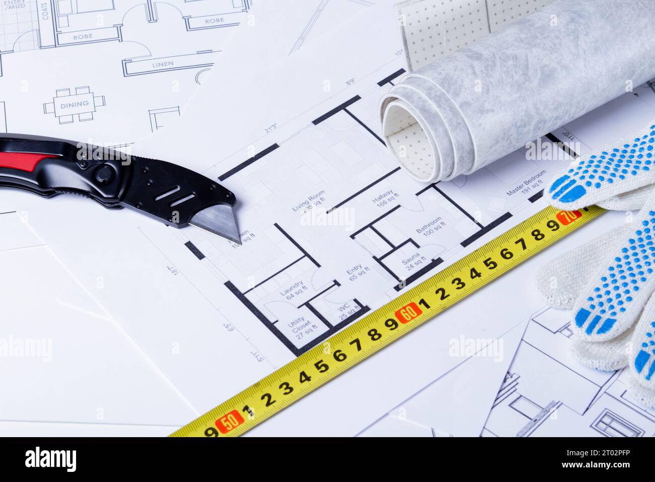 Laying flooring. Linoleum, a knife and a house plan on the builder's ...