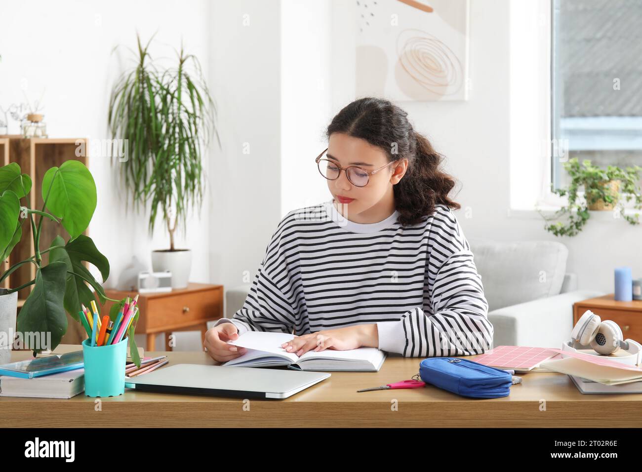 Female student reading schoolbook at home Stock Photo - Alamy