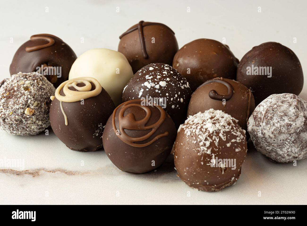 Assorted chocolate truffles of various flavors on a marble background ...