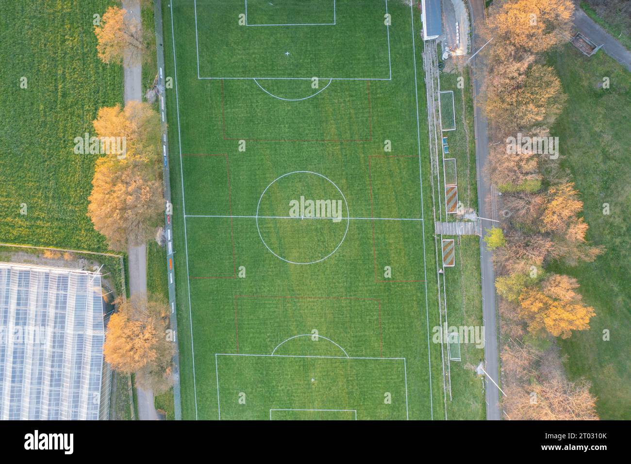 A soccer field viewed from above. A bit misshapen. A lawn robot mows ...