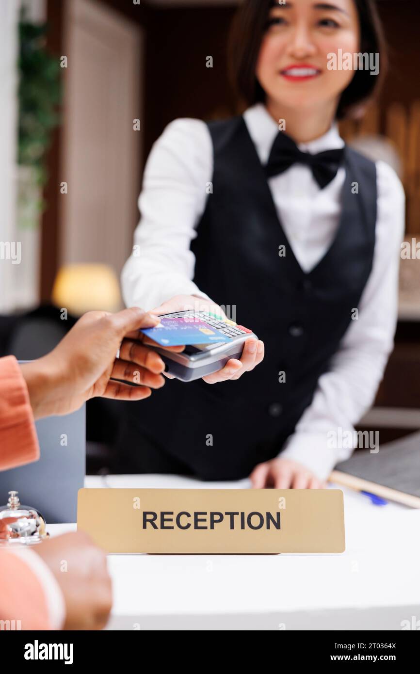 Woman guest paying at pos terminal in luxury resort, using electronic ...