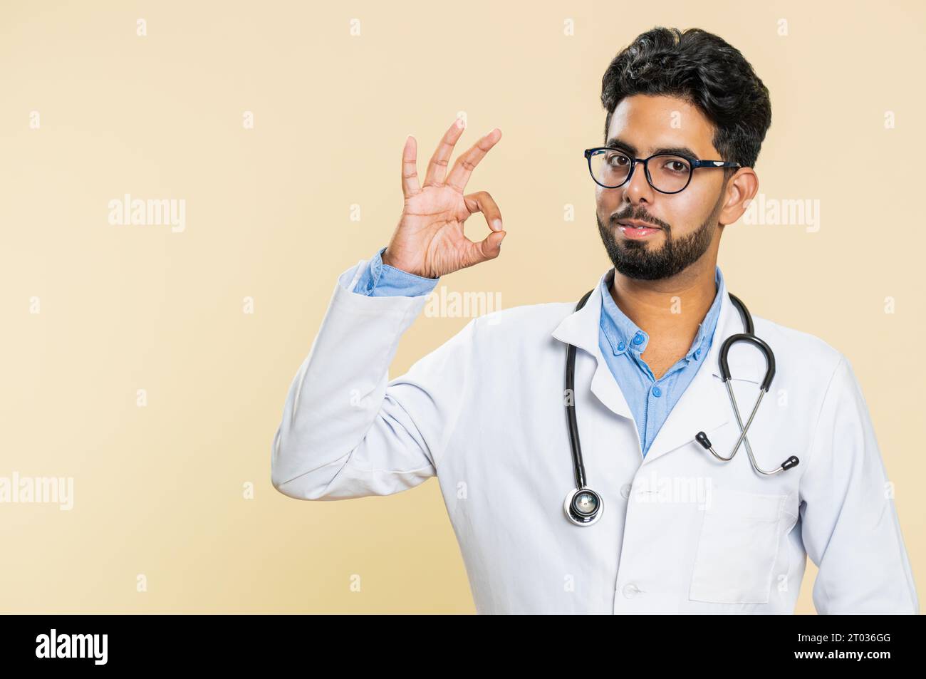 Okay. Happy Indian young doctor cardiologist man show ok gesture, like ...