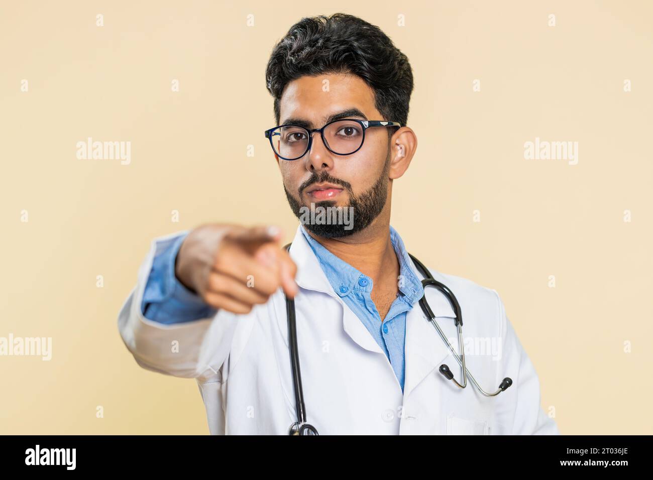 Hey you. Happy strict Indian young doctor cardiologist man pointing ...
