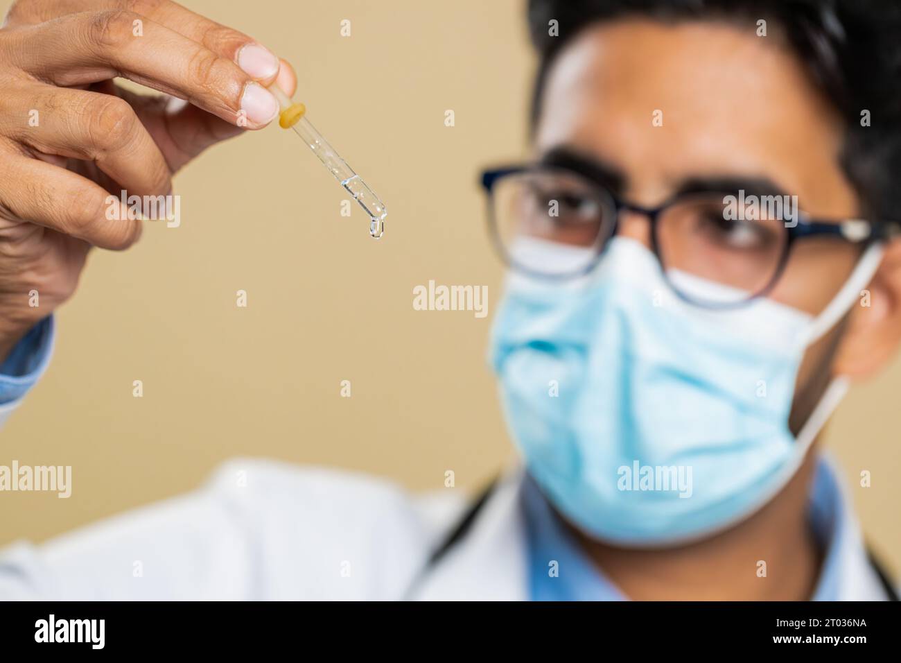 Indian young doctor cardiologist scientist man carefully drips the ...