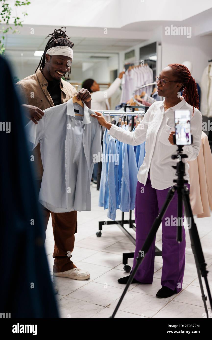 Fashion blogger and clothing store owner showcasing shirt for online ...