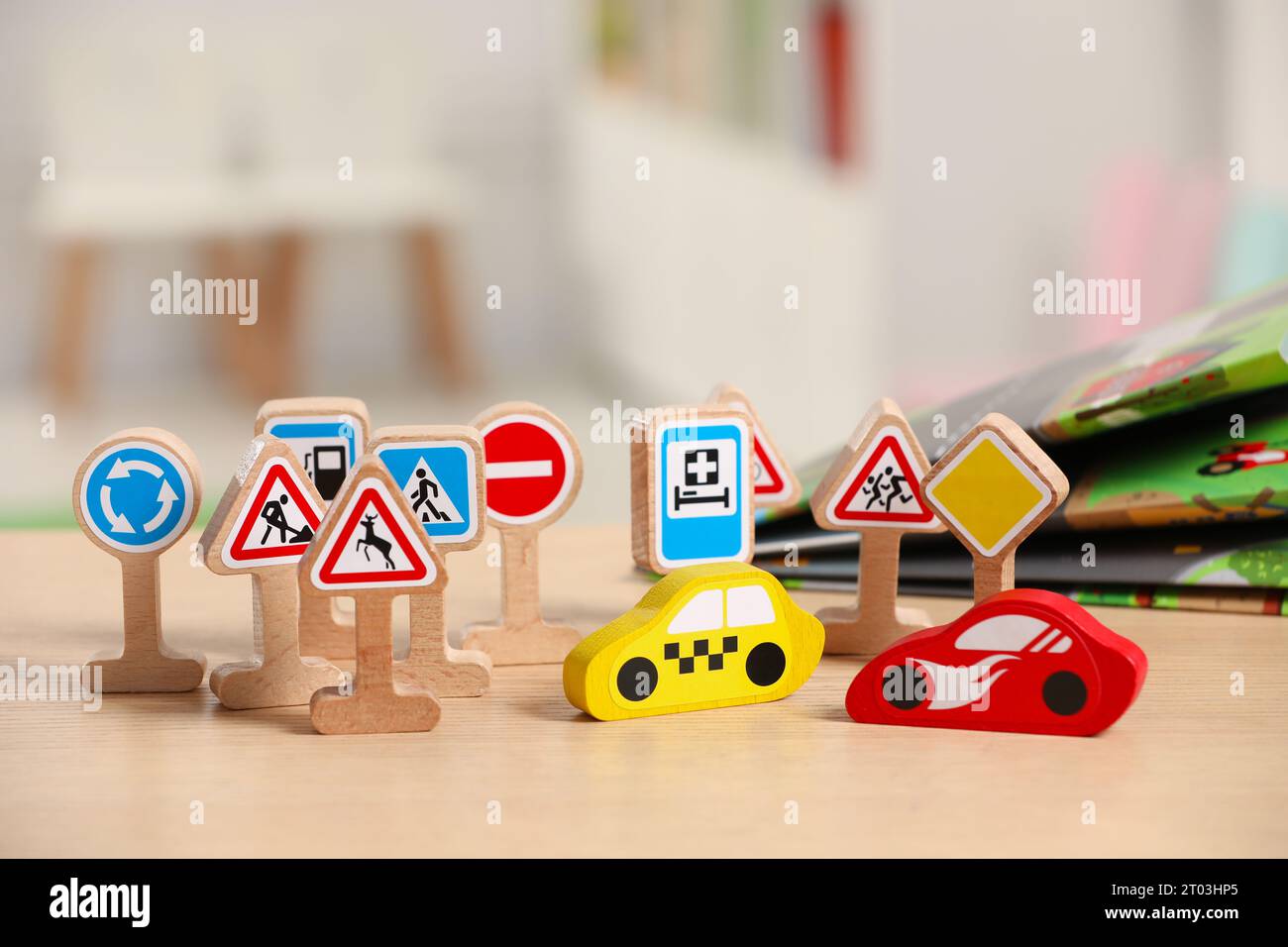 Set of wooden road signs and cars on table indoors, closeup. Children's ...