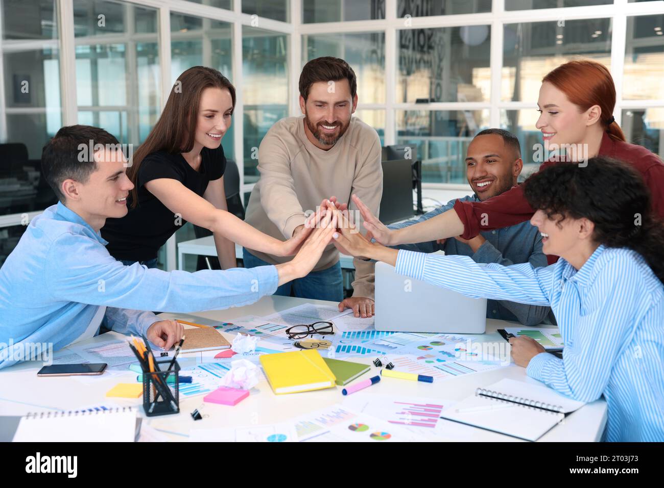 Team of employees joining hands in office. Startup project Stock Photo ...