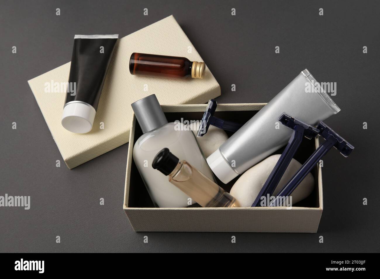 Different men's shaving accessories and box on dark grey background ...