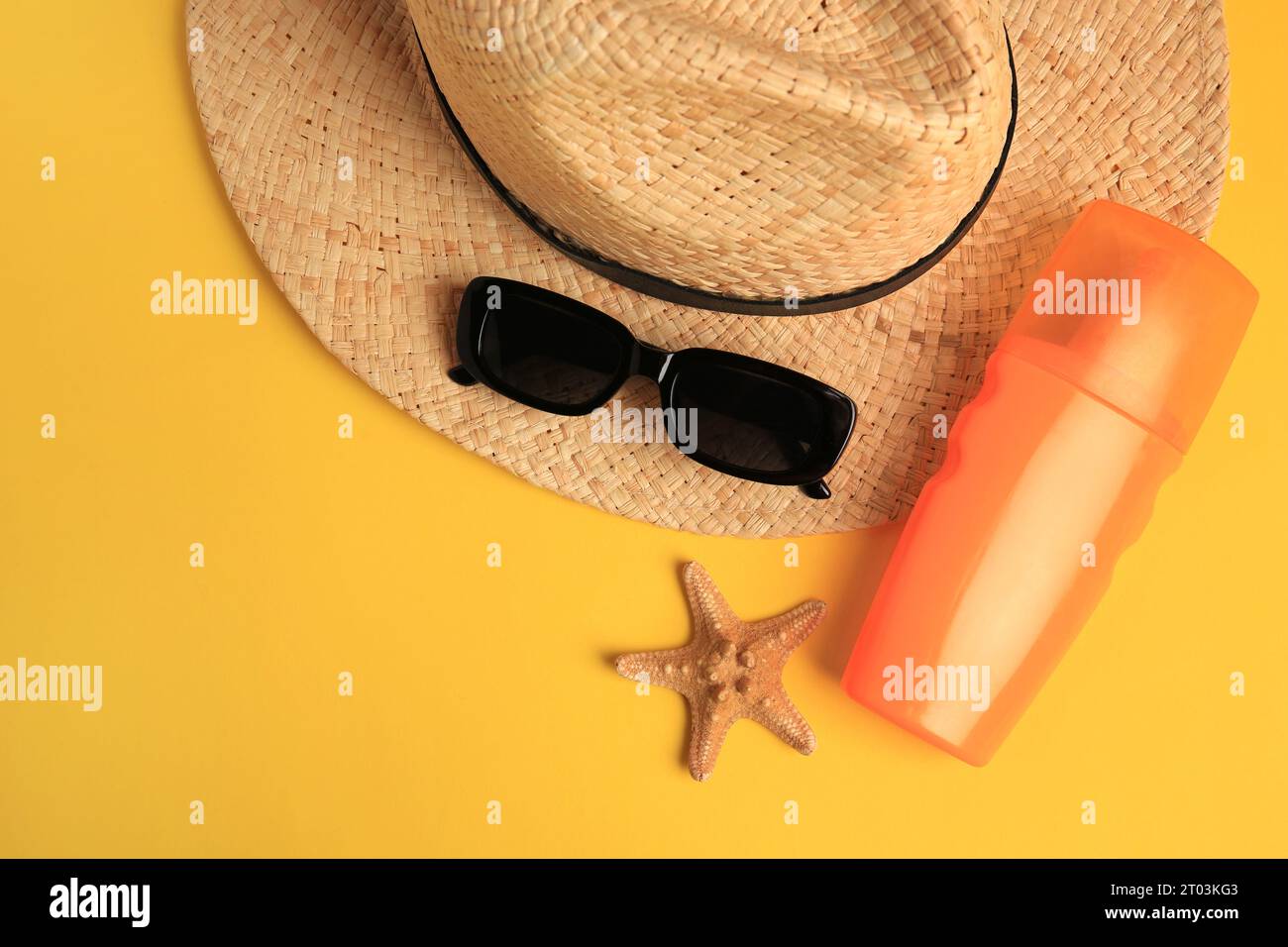 Flat lay composition with bottle of sunscreen on yellow background ...