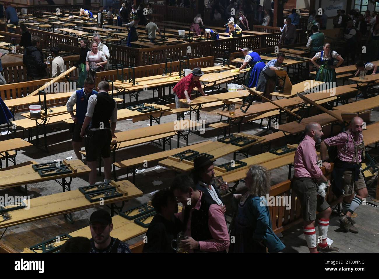Munich, Germany. 03rd Oct, 2023. Waiters and waitresses clear up benches and tables after the ...