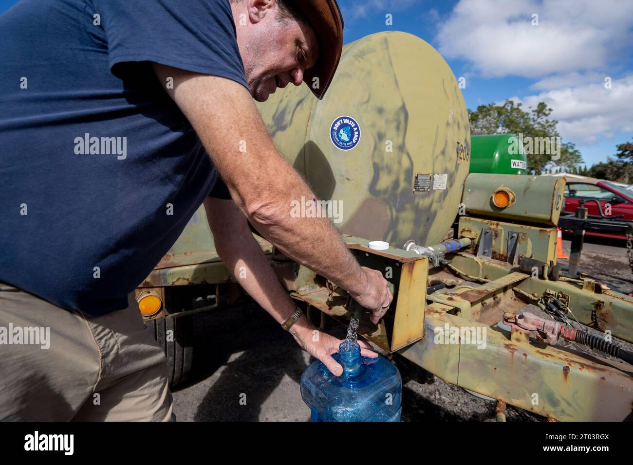 Jim Rensberger fills up a jug from a water buffalo at Kula distribution ...