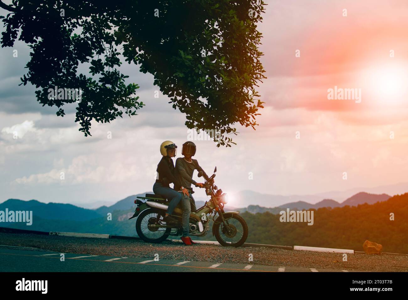 couples wearing safety helmet sitting on small enduro motorcycle ...