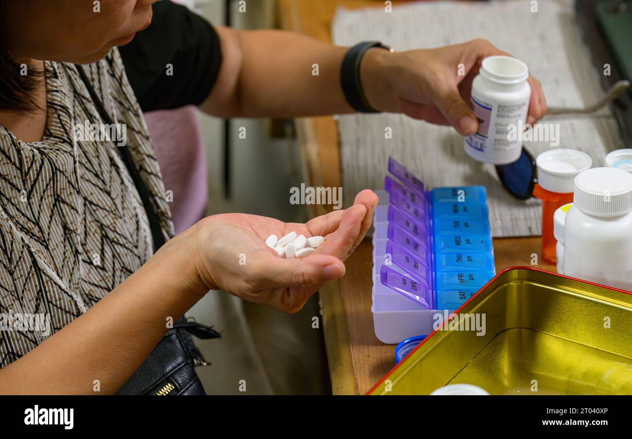 Woman sorting pills into medical pill boxes Stock Photo - Alamy