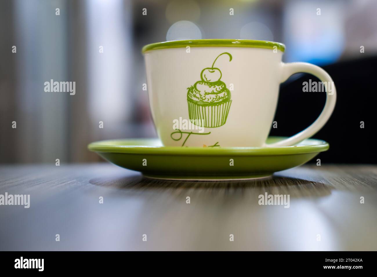 A green teacup with a defocused background Stock Photo - Alamy