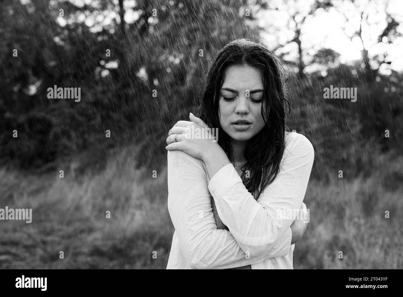 Sad woman under summer rain, black and white photo. Emotional girl wet ...