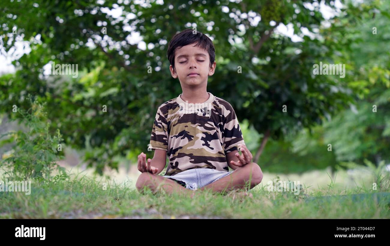 Close up of chid meditating in lotus position. Small kid practicing ...