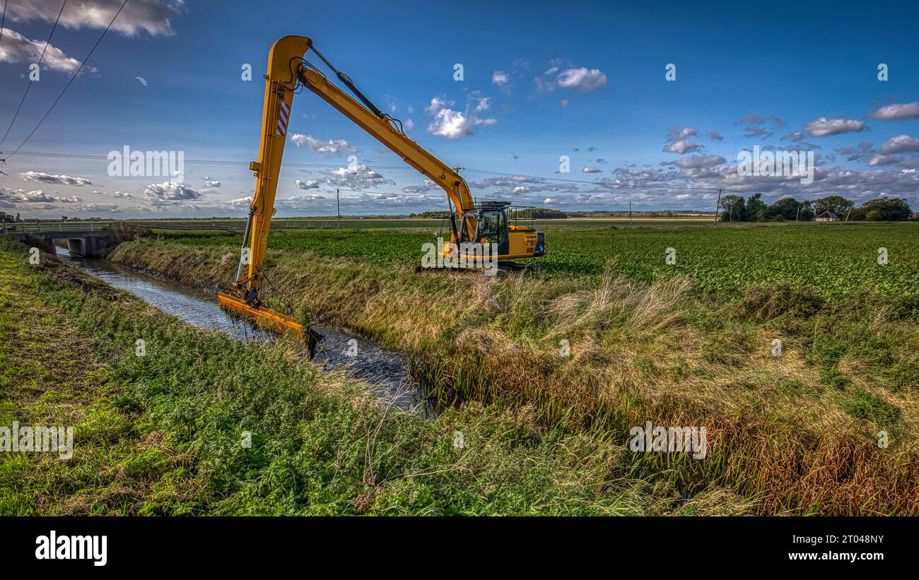 Reed cutting excavator clearing drainage ditches in the flat lands of ...