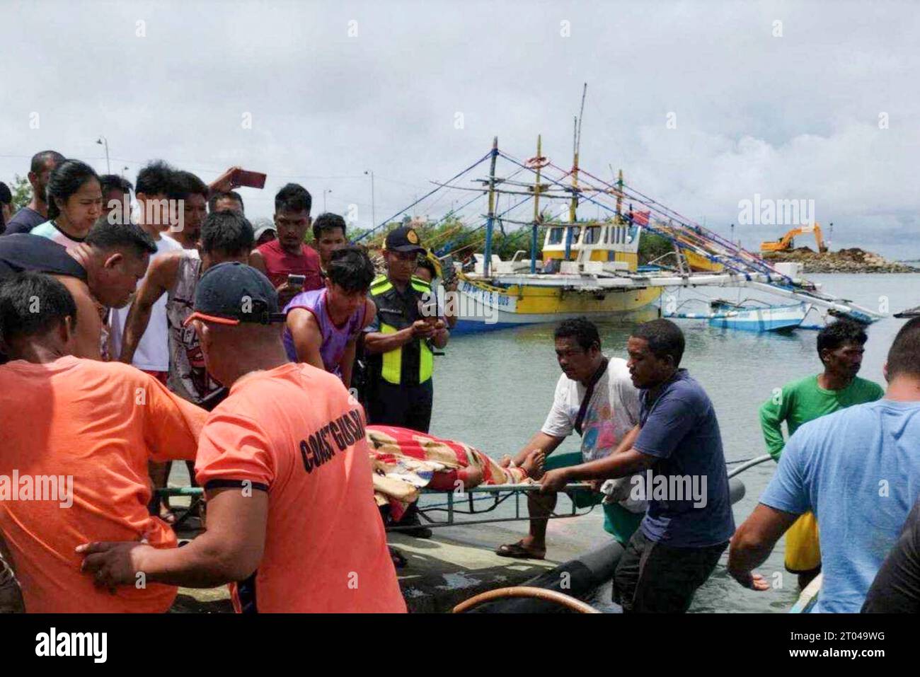 In this photo provided by the Philippine Coast Guard, rescuers carry the body of one of the ...