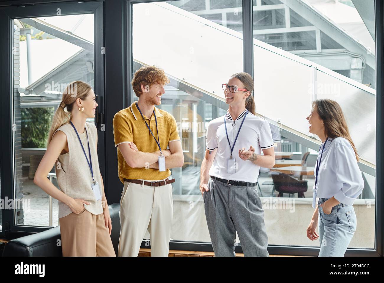 four young employees in smart casual outfits smiling sincerely ...
