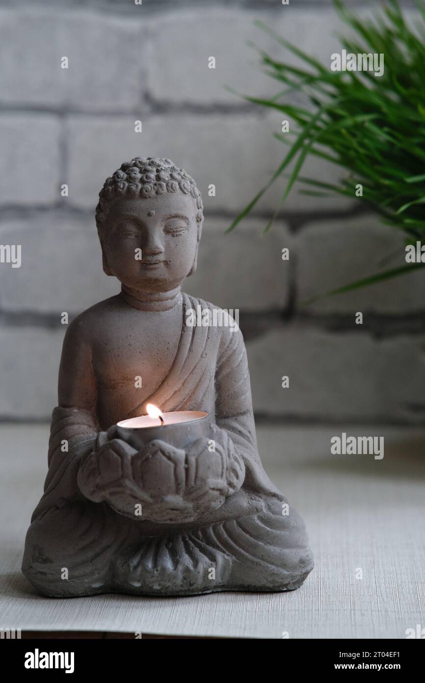 a small stone statue of Buddha Stock Photo - Alamy