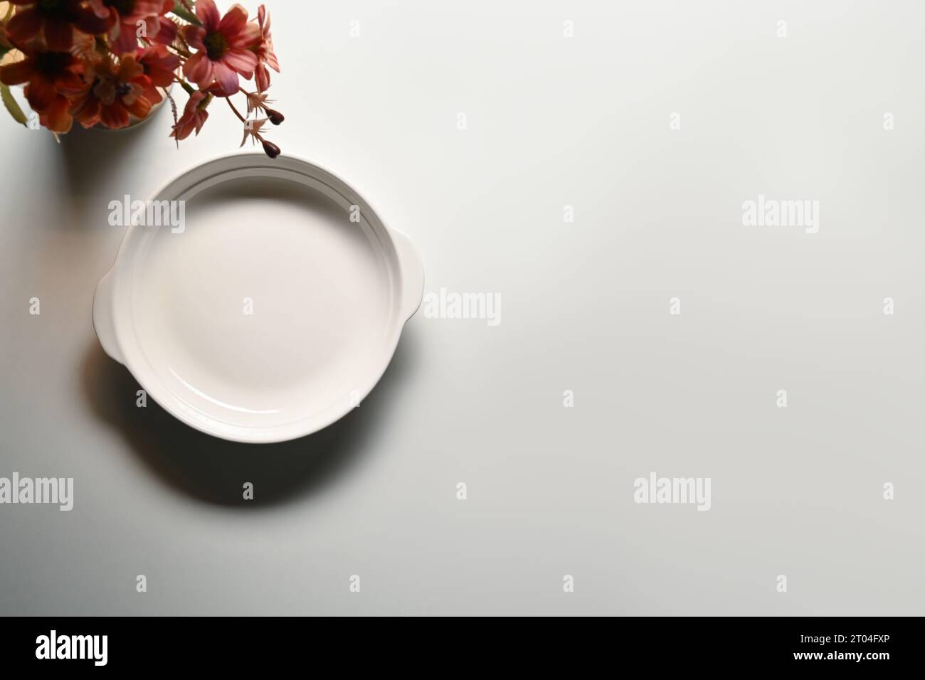 A round ceramic pottery plate on white background. Flat lay, top view ...