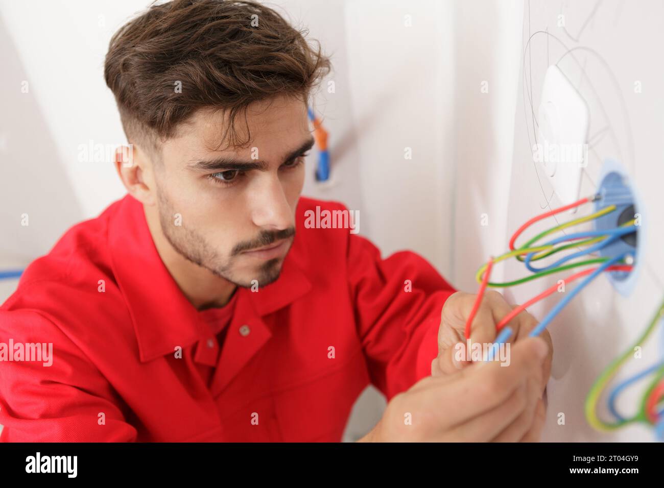 young electrician fixing a socket Stock Photo - Alamy