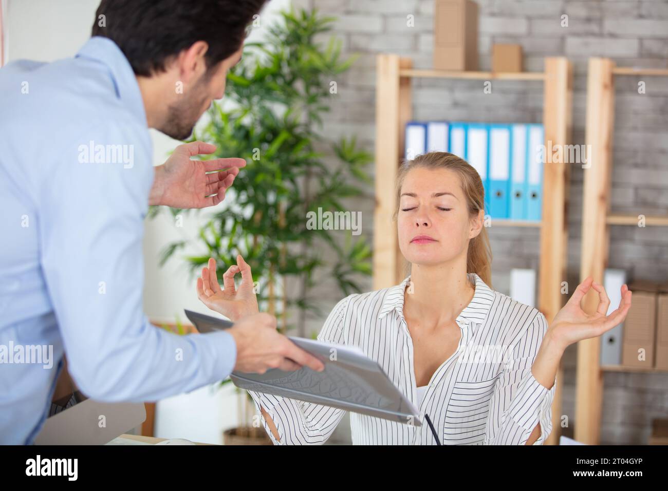 businesswoman meditating in office and ignoring pressuring boss Stock ...