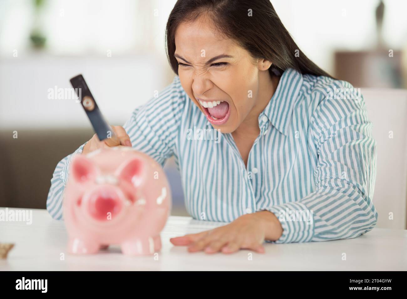 woman breaking a piggybank Stock Photo - Alamy