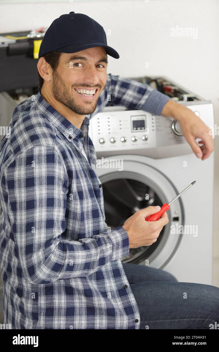 portrait of happy technician repairing a washing machine Stock Photo ...
