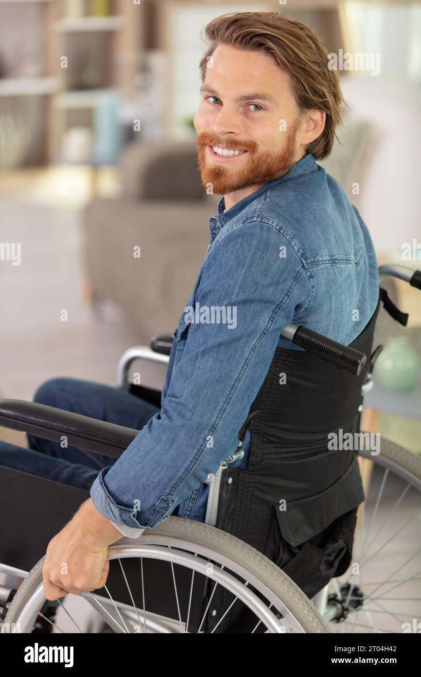 young handicapped man sitting on wheelchair at home Stock Photo - Alamy