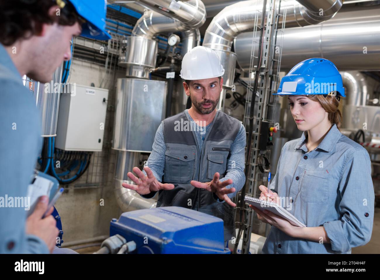 workman warning colleagues not to touch machinery Stock Photo - Alamy