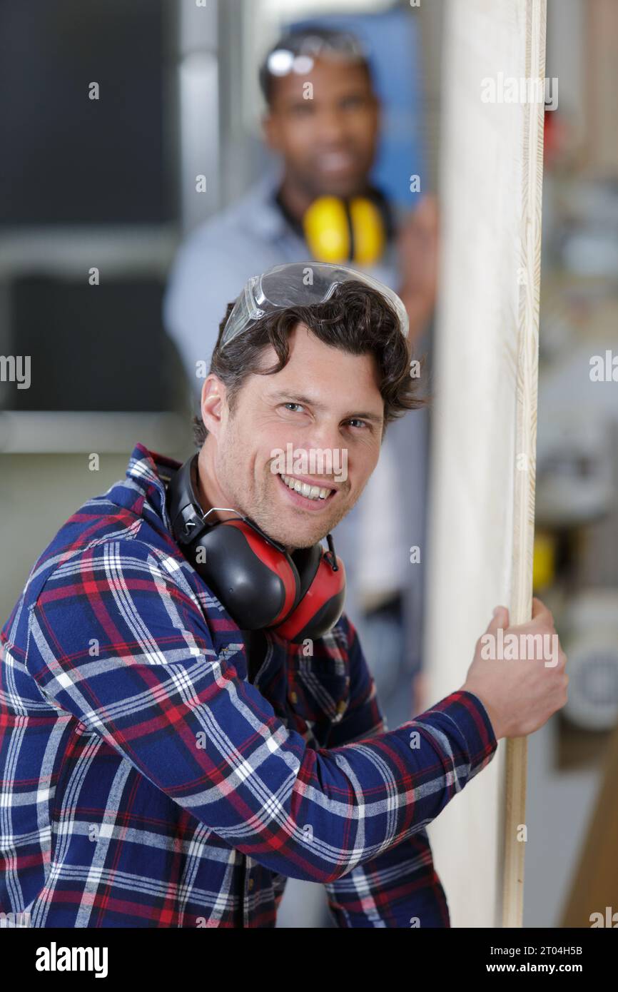 happy male carpenter with wood plank Stock Photo - Alamy