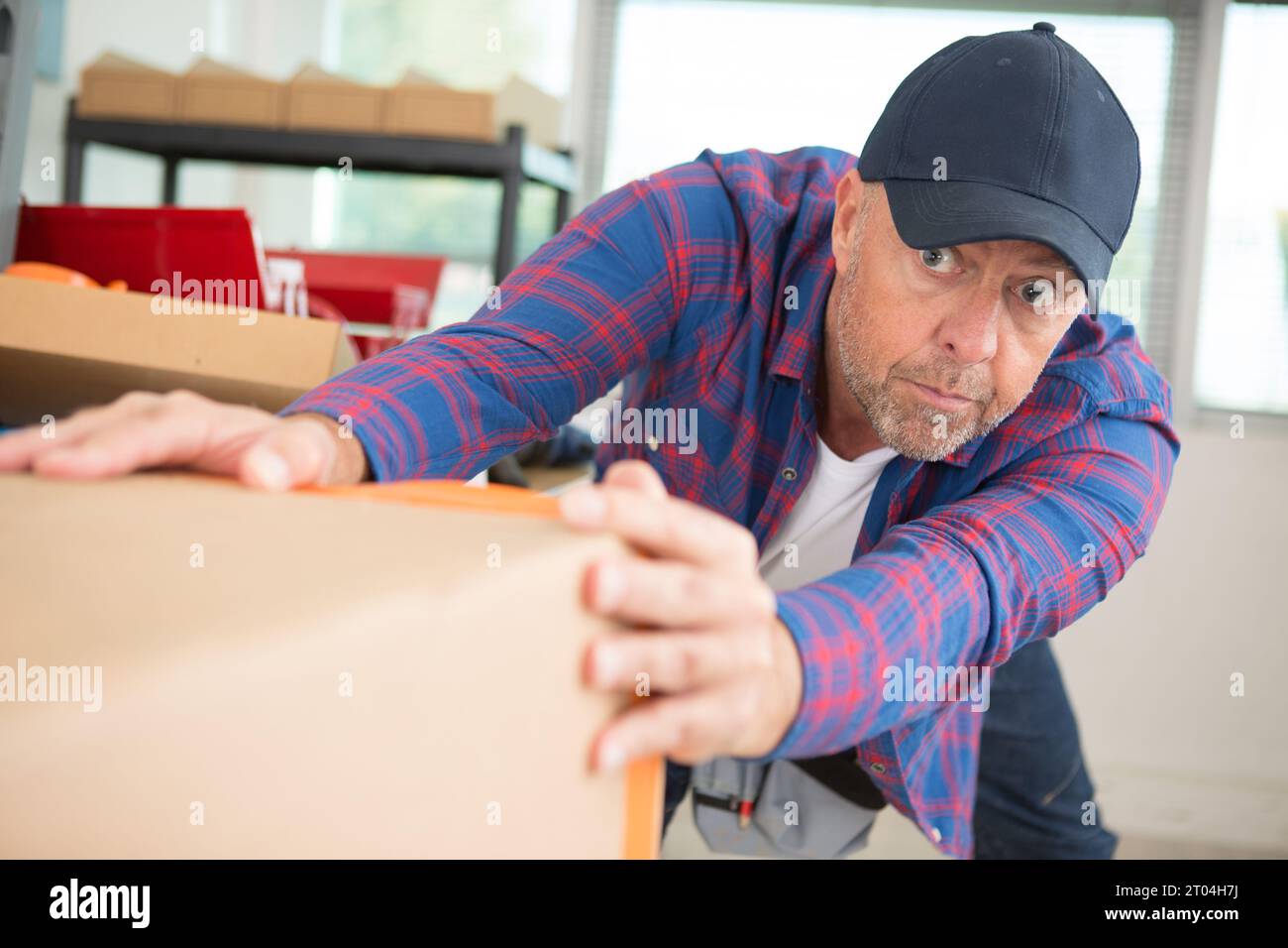 a man is moving a heavy box Stock Photo - Alamy