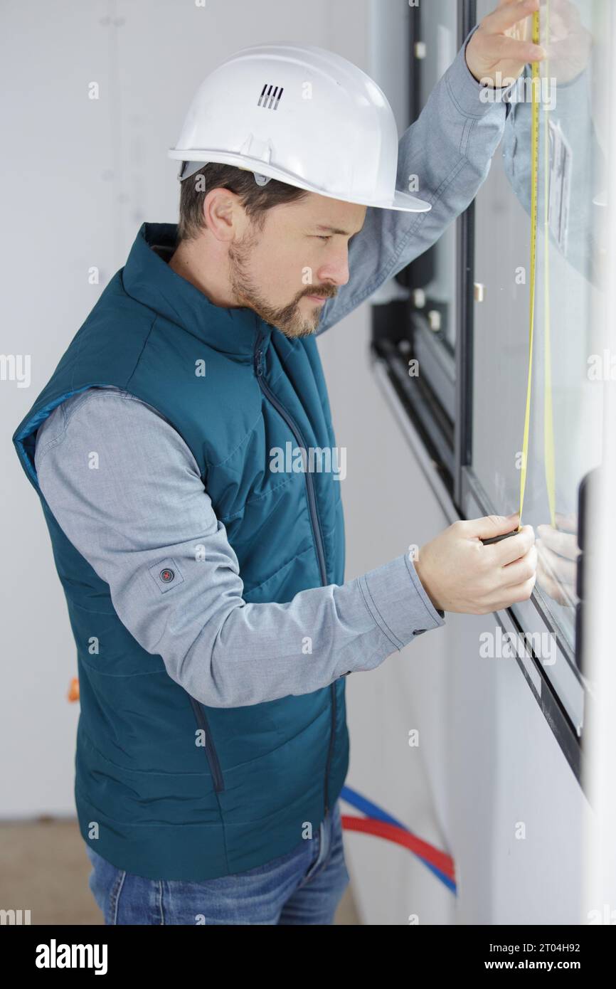man measuring window with tape measure on white Stock Photo - Alamy