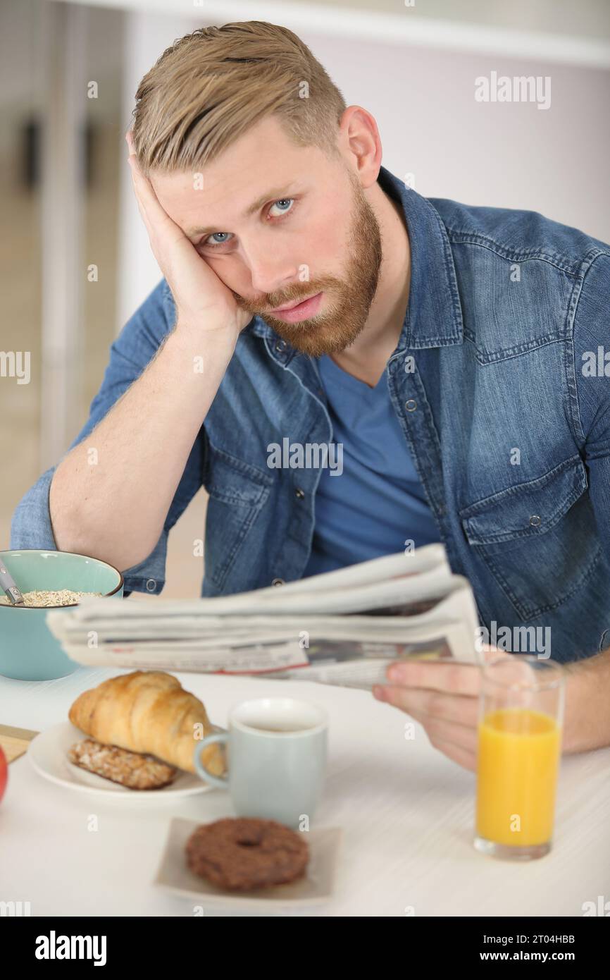 bored man reading the newspaper at the breakfast table Stock Photo - Alamy
