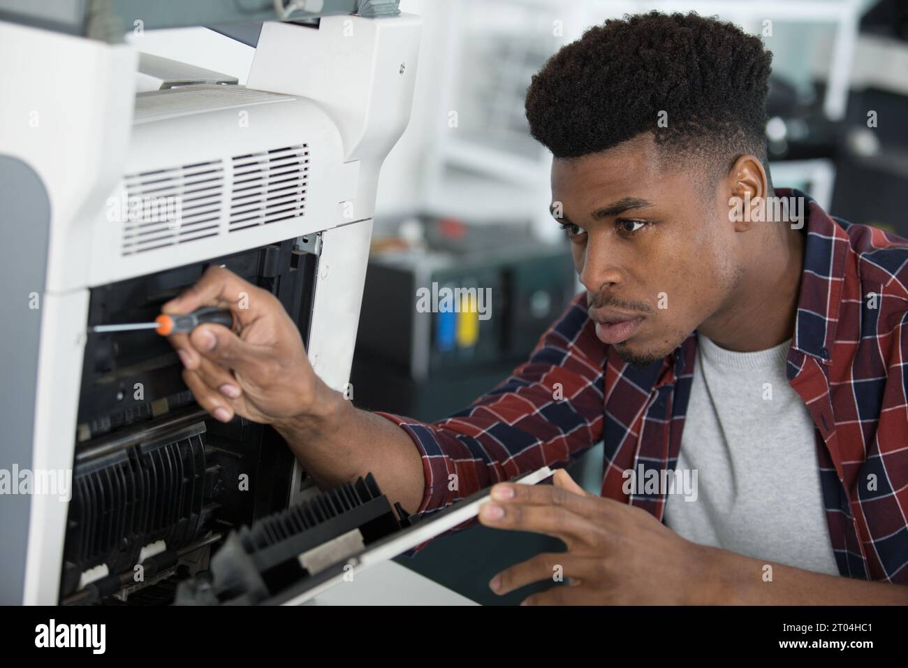 closeup shot young male technician repairing digital photocopier ...