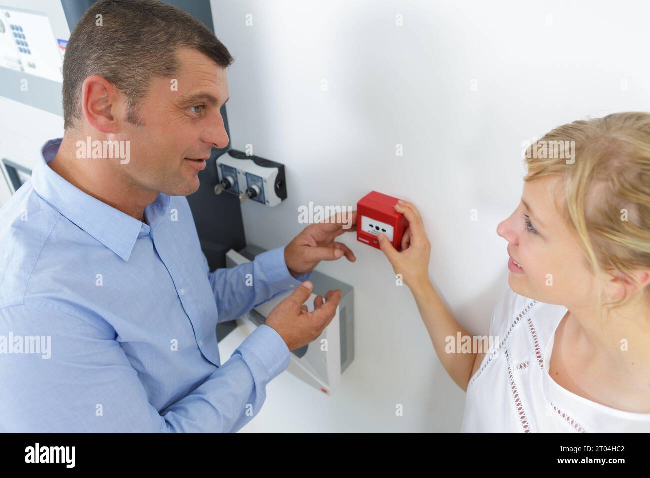 man and woman talking about fire alarm Stock Photo - Alamy