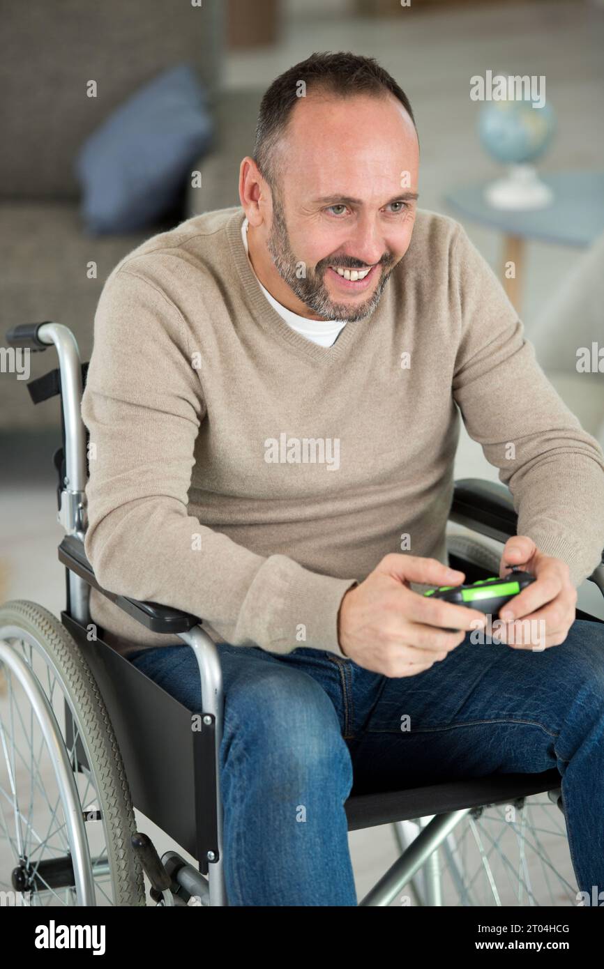 middle aged disabled man playing a computer game Stock Photo - Alamy