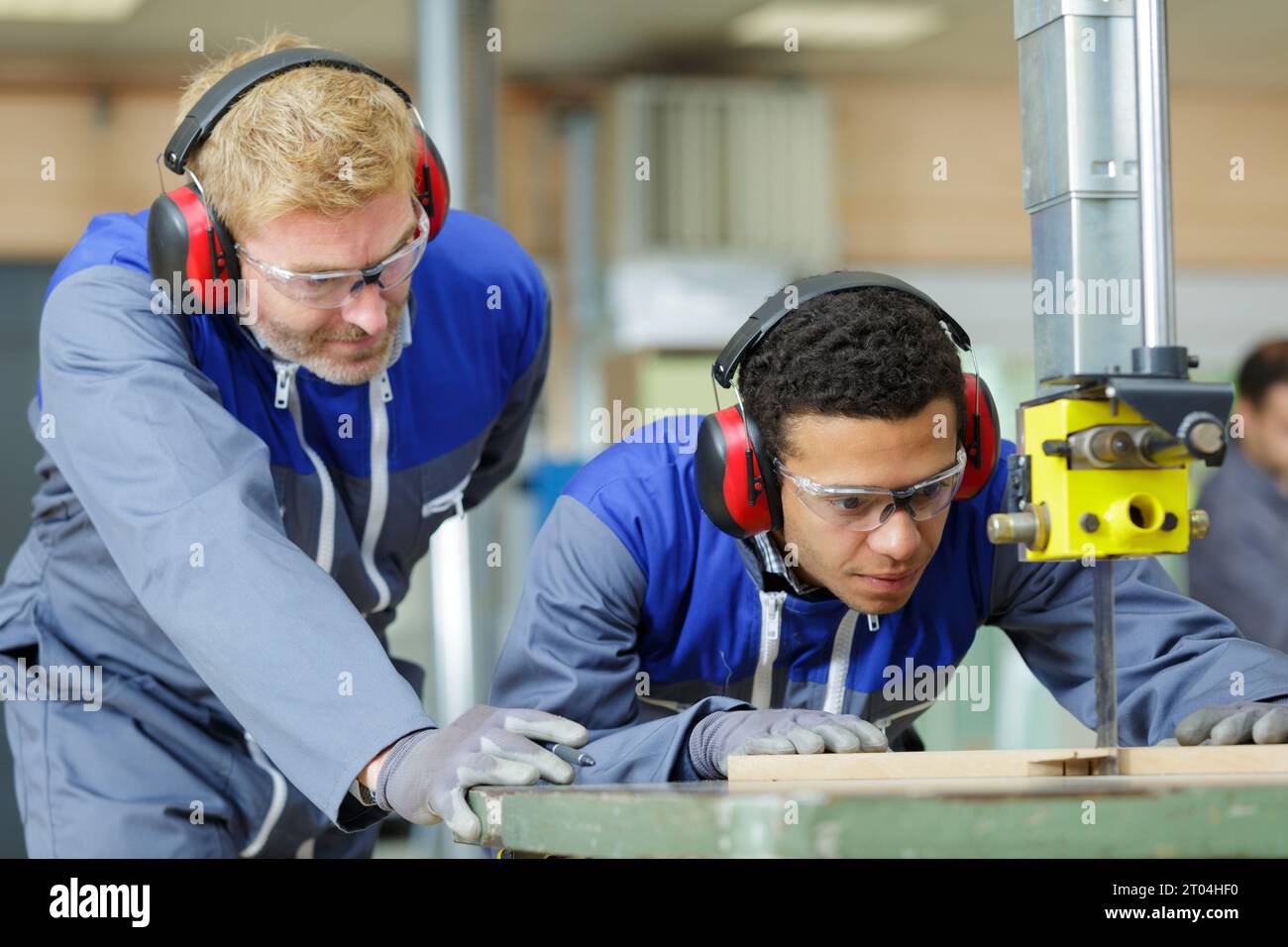 trainee carpenter using band saw under supervision Stock Photo - Alamy