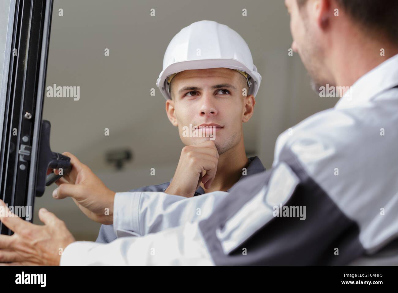 concentrated young builder installing a window Stock Photo - Alamy
