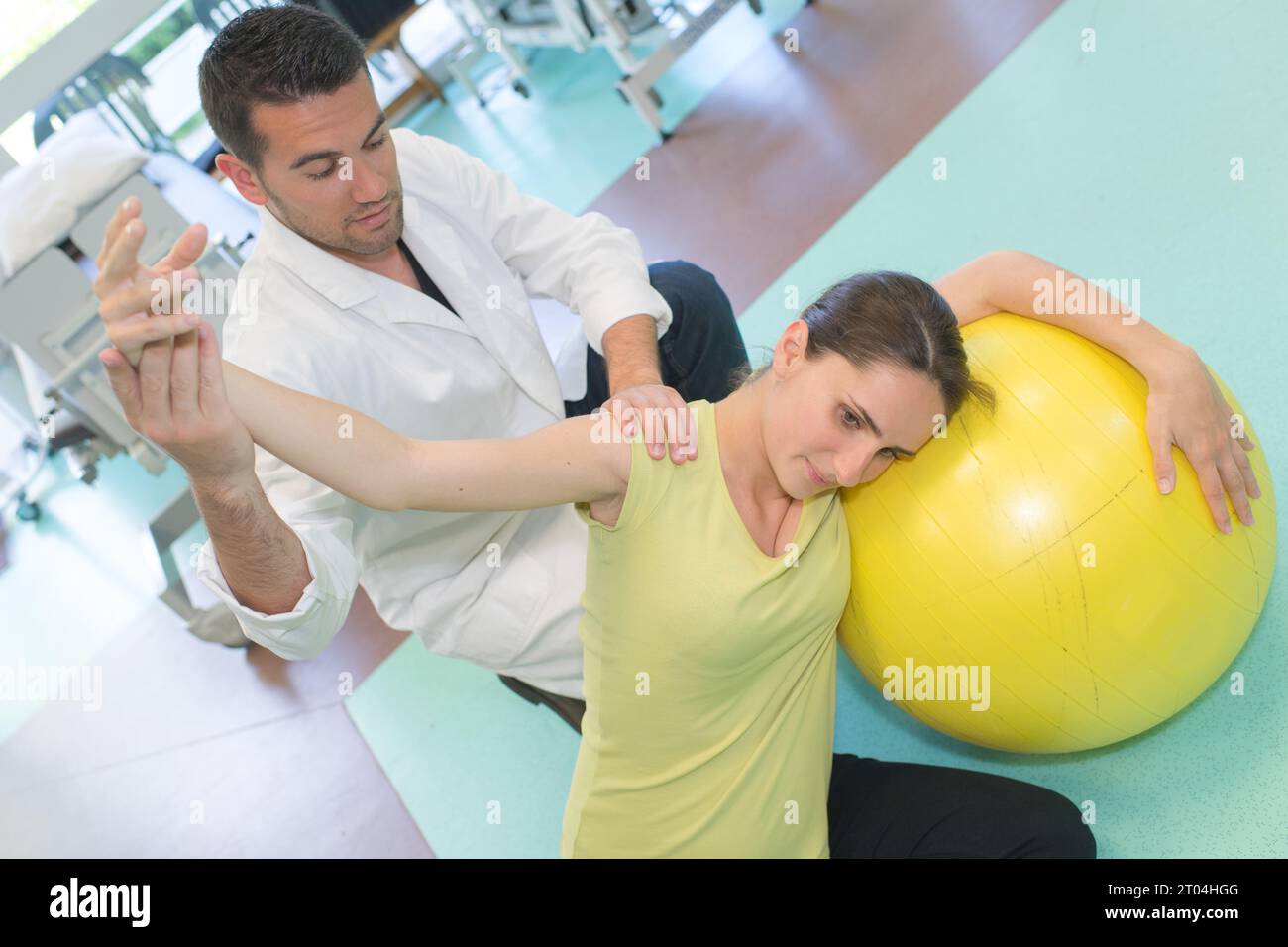 therapist examining the injured shoulder of a female patient Stock ...